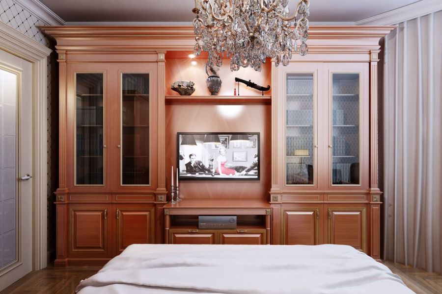 Книжный шкаф коричневого дерева с нишей под телевизор в интерьере спальни